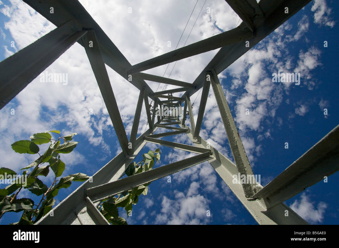 Inside of a gray power pylon under a deep blue sky with white clouds ...