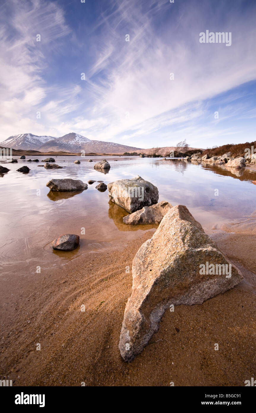 High level clouds clear over a frozen loch in the desolate Rannoch Moor ...