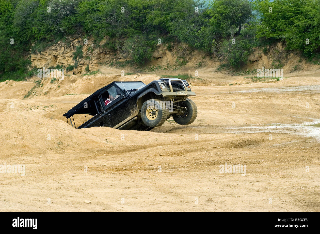Land Rover defender driving off road climbing a steep hill in the UK ...