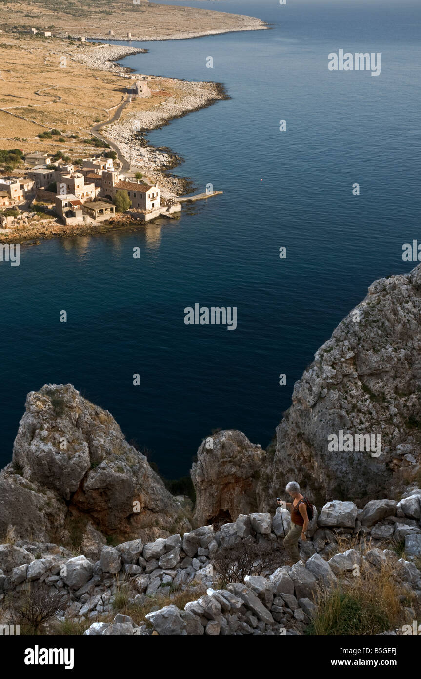 A walker on a steep Kalderimi, stone path, above the little fishing ...