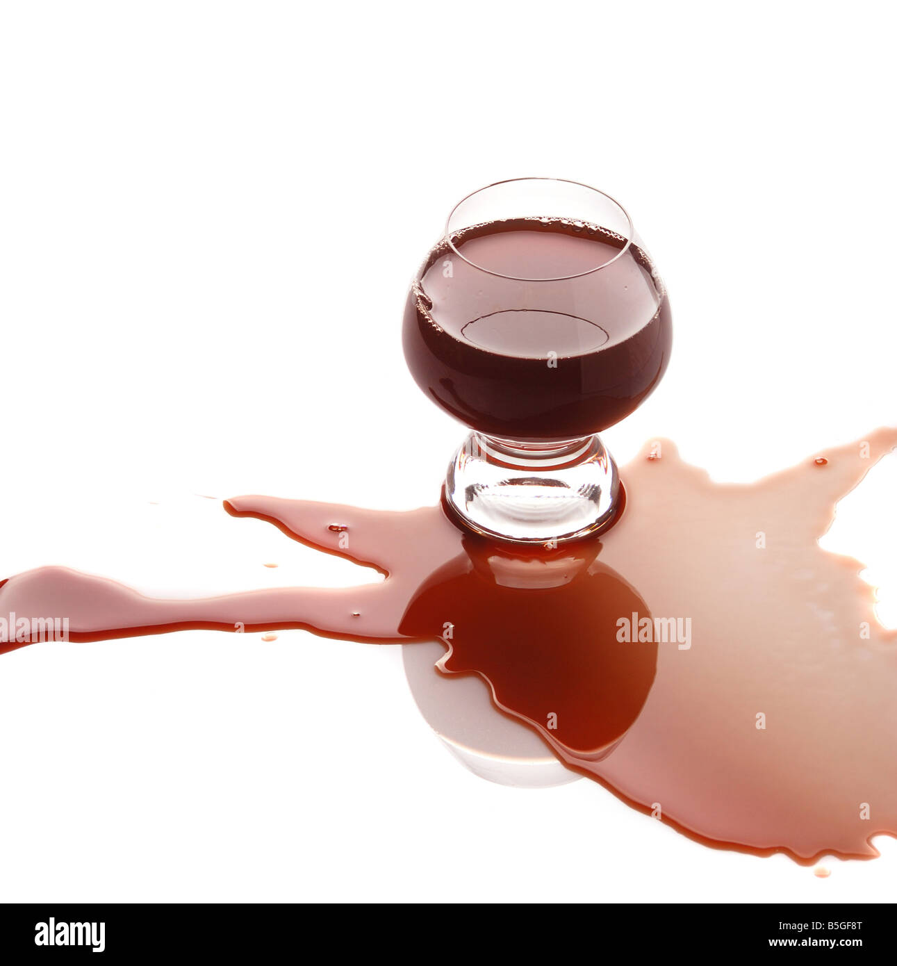 The spilled red wine Wine poured on a surface is isolated on a white ...