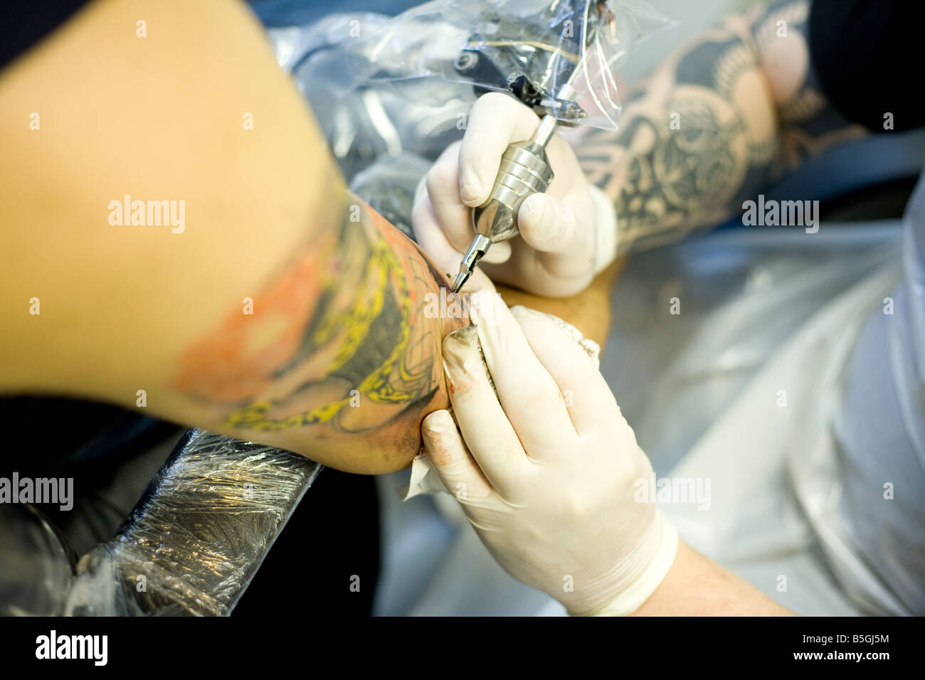 Man having his arm tattooed Stock Photo - Alamy