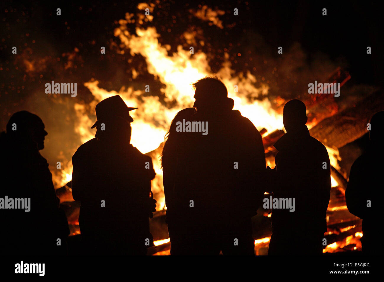 People standing around a bonfire Stock Photo - Alamy