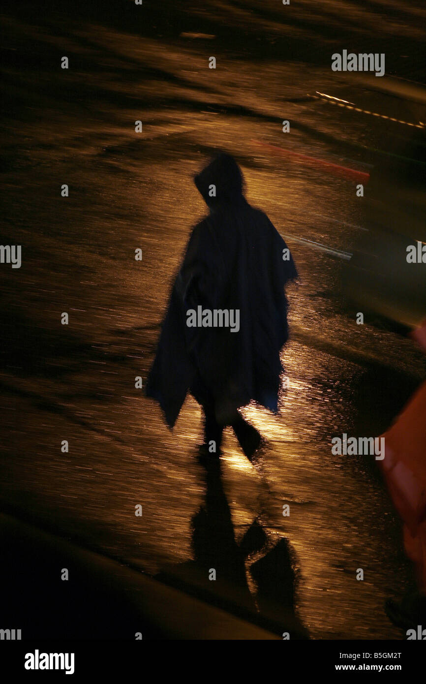 person walking in heavy rain at night in town Stock Photo - Alamy