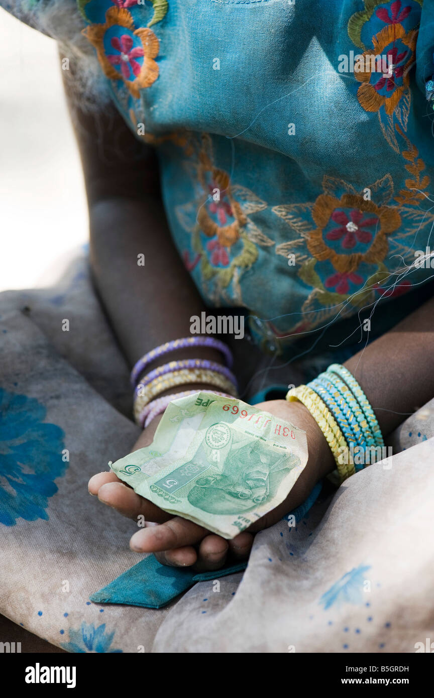 Hands of an Indian child begging holding five rupee note. Andhra ...