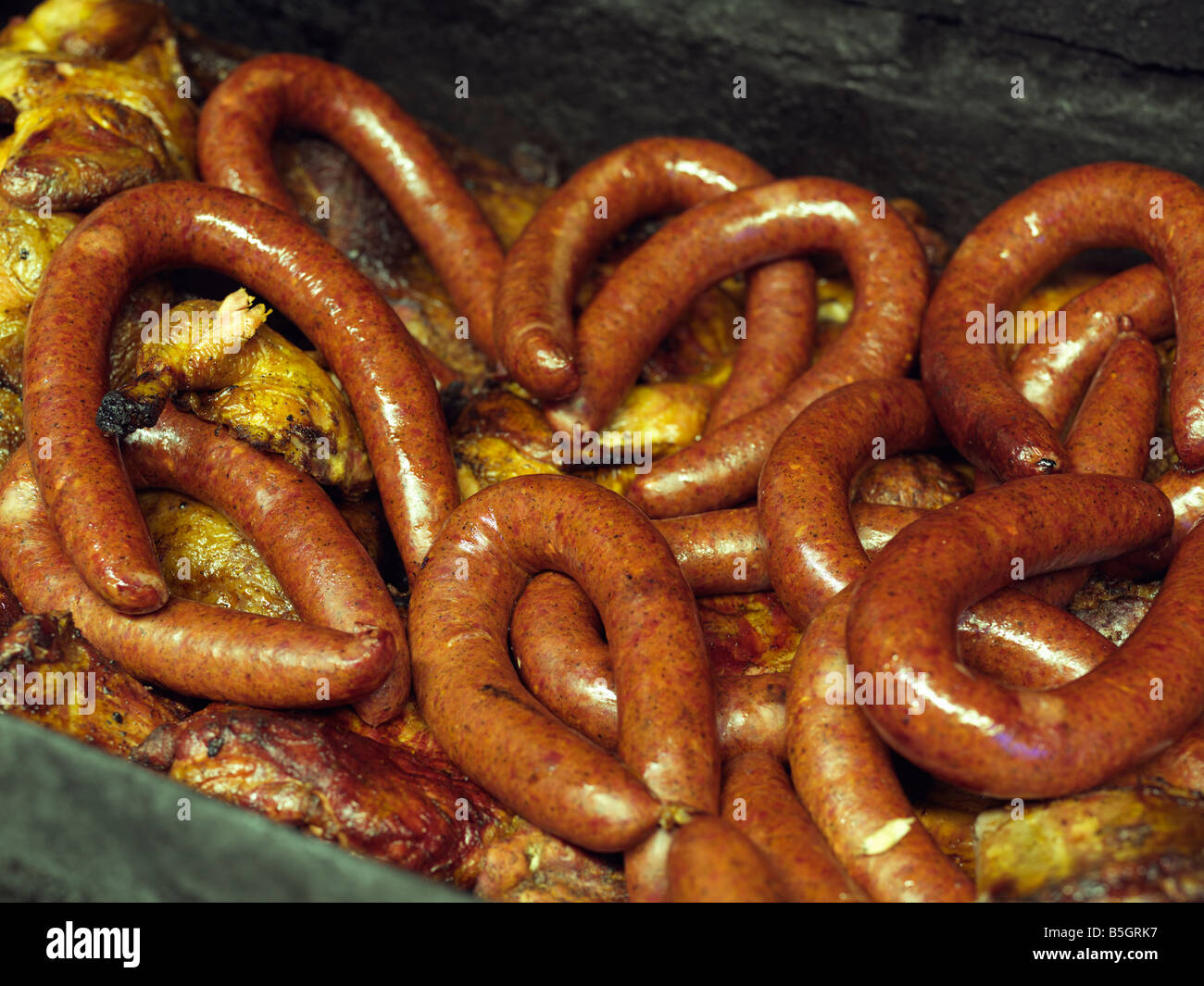 USA,Texas,Houston,sausage and chicken grilling in an open pit BBQ grill ...