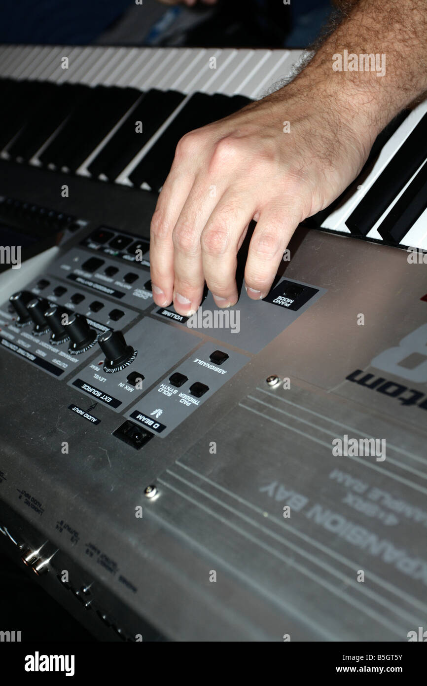 Hand on silver keyboard controls Stock Photo - Alamy