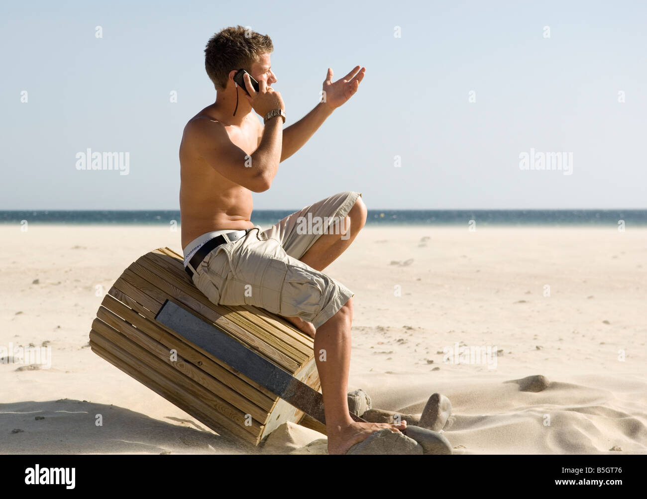 man at the beach talking on his celular phone Stock Photo - Alamy