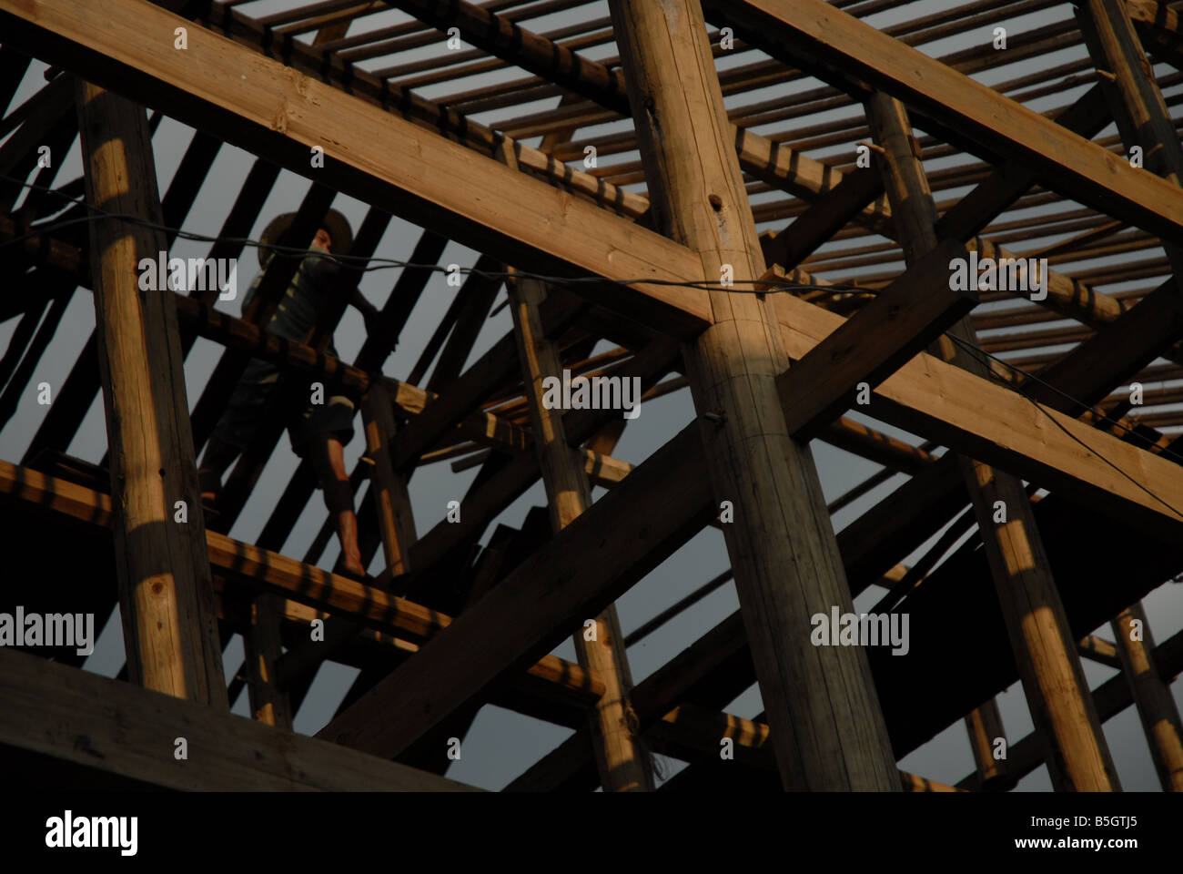 The frame of a traditional wooden house being built in Miao (Hmong ...