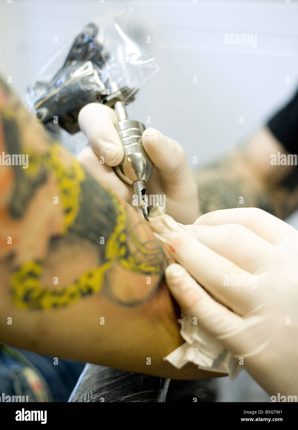 Man having his arm tattooed Stock Photo - Alamy