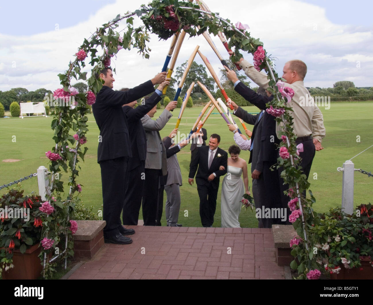 Staffordshire UK August Bride and groom walking up steps past guard of ...
