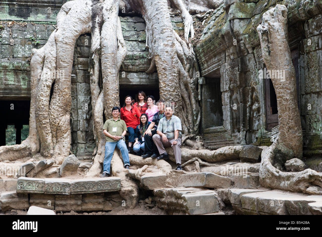 Visitors inside the overgrown temple of Ta Prohm Temples of Angkor Siem ...