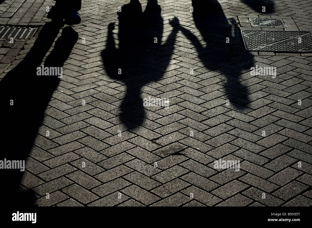 The shadow of two children holding hands in central London Stock Photo ...