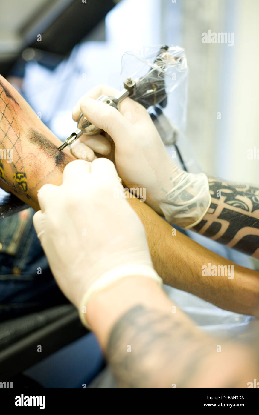 Man having his arm tattooed Stock Photo - Alamy