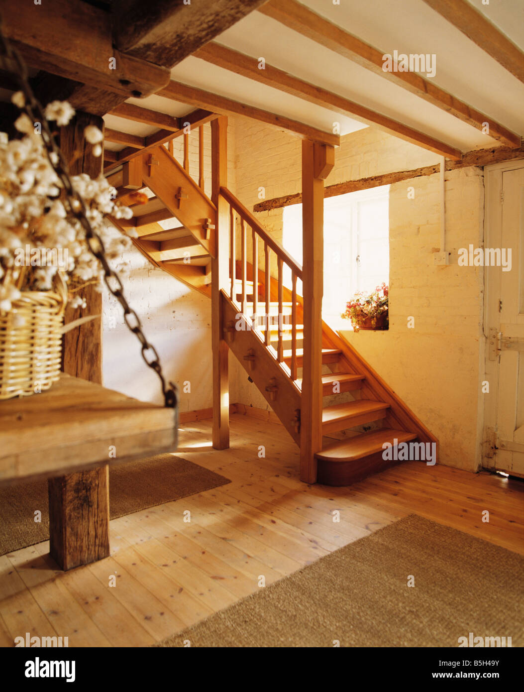 Wooden open-tread staircase in cream cottage hall with wooden flooring ...