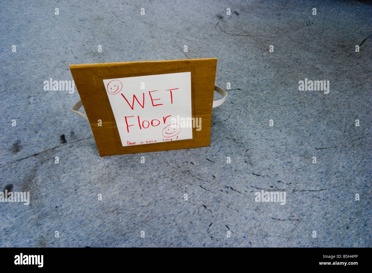 Sign on a floor that reads WET FLOOR LOCATION RELEASED Stock Photo - Alamy