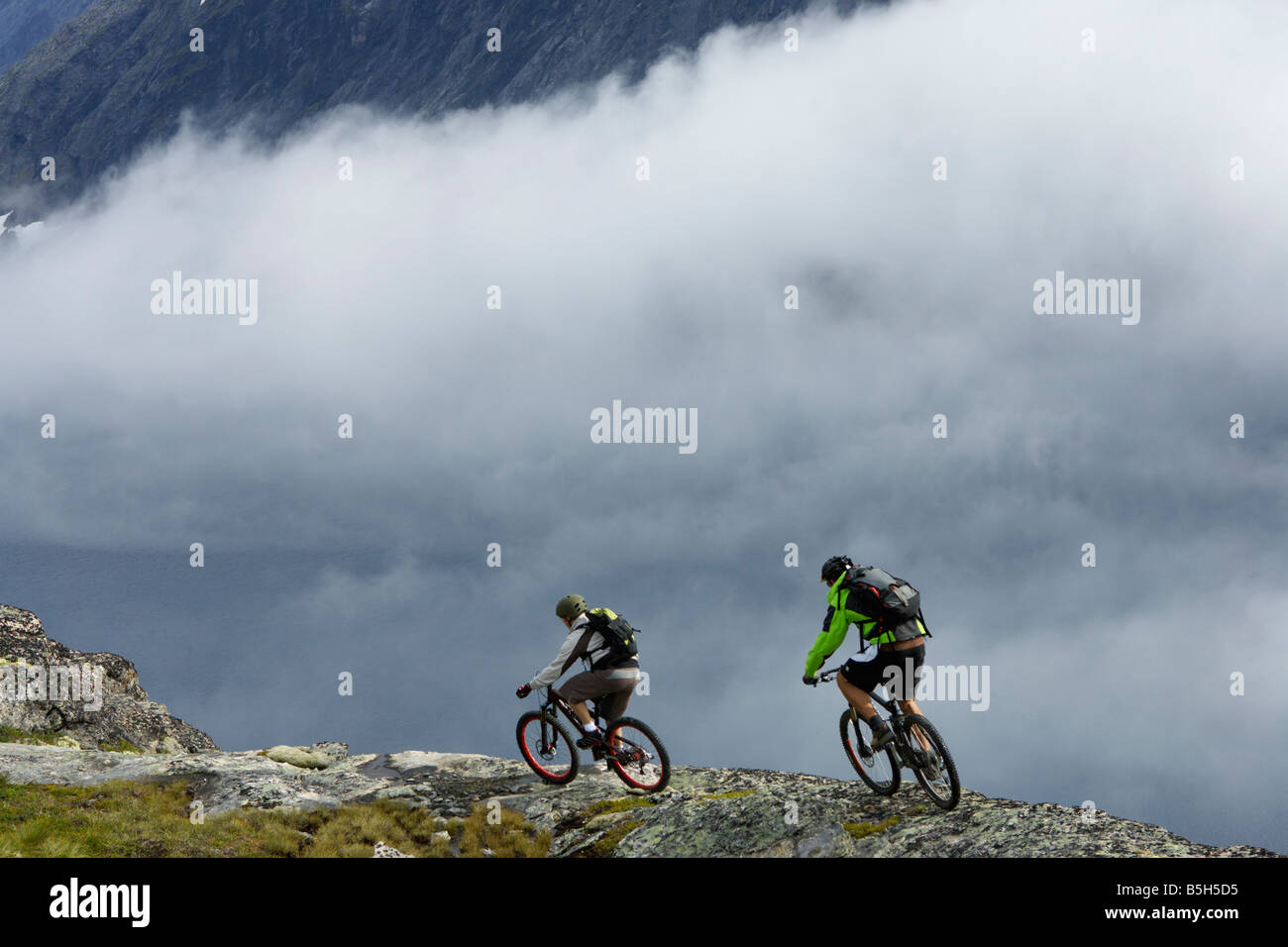 Mountainbike riders in front of a fog zone Stock Photo - Alamy
