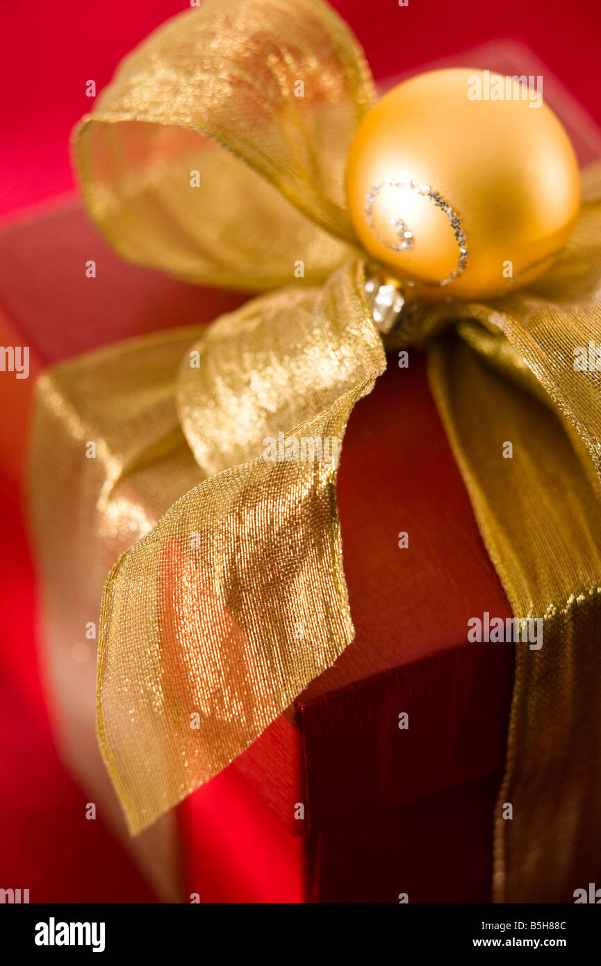 red gift box with a metallic gold ribbon Stock Photo - Alamy