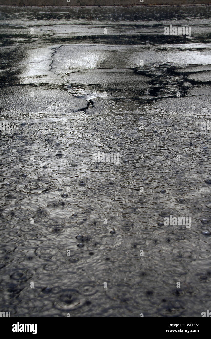 lots rain drops falling in water puddle in street Stock Photo - Alamy