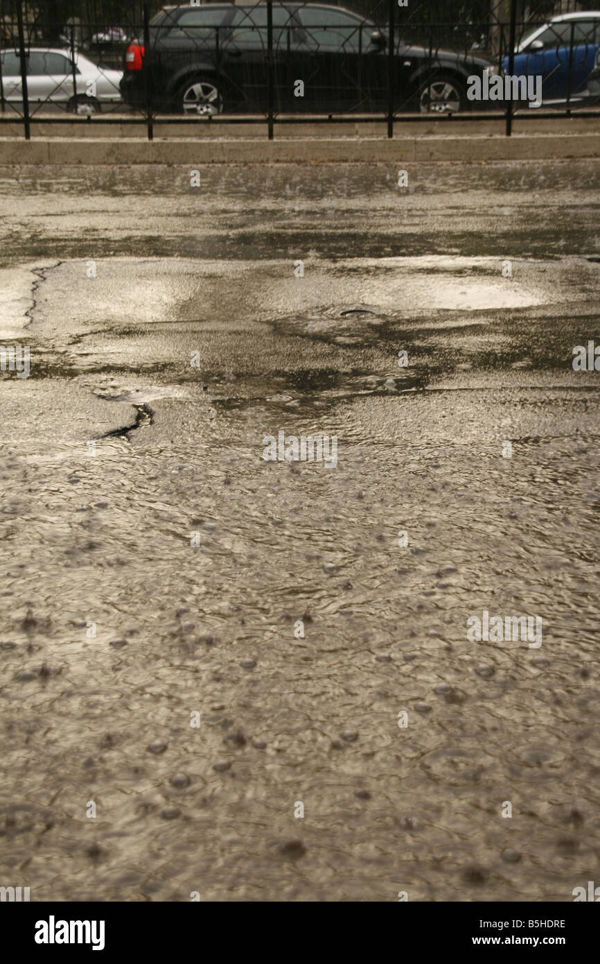 lots rain drops falling in water puddle in street Stock Photo - Alamy
