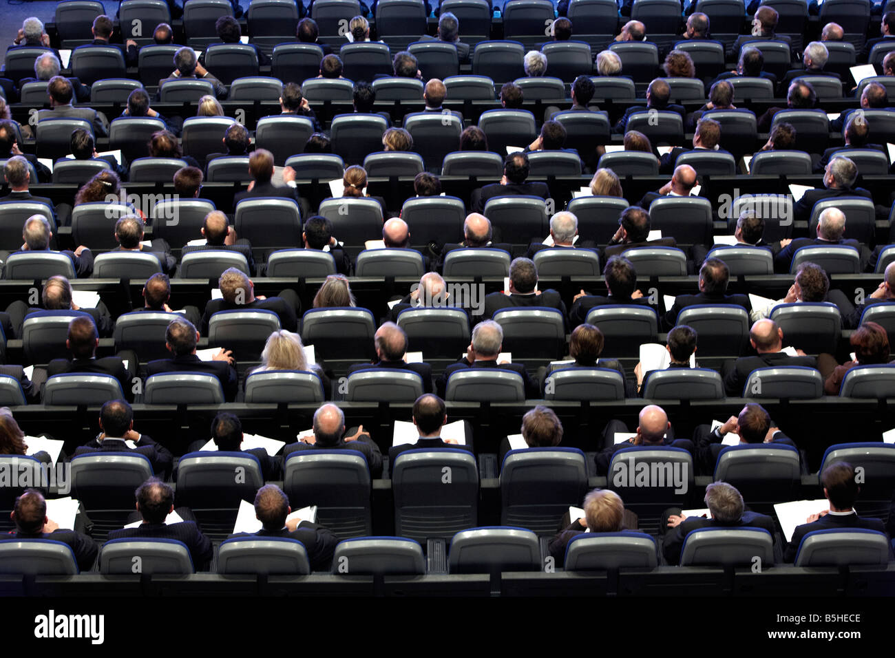 Delegates sit and listen to a speaker at a business conference Stock ...