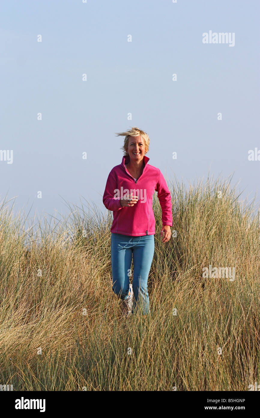 Female running through long grass hi-res stock photography and images ...