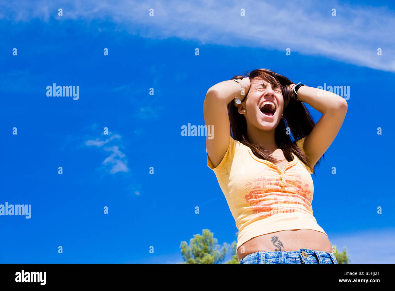 Screaming woman over blue sky as background Stock Photo - Alamy