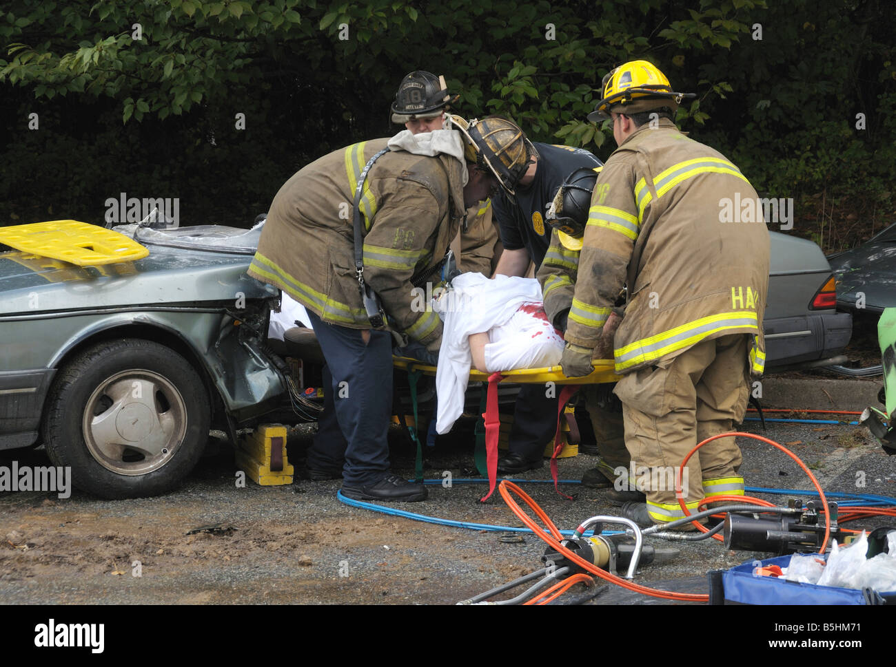 firefighters remove an injured man from a car on a backboard after a ...