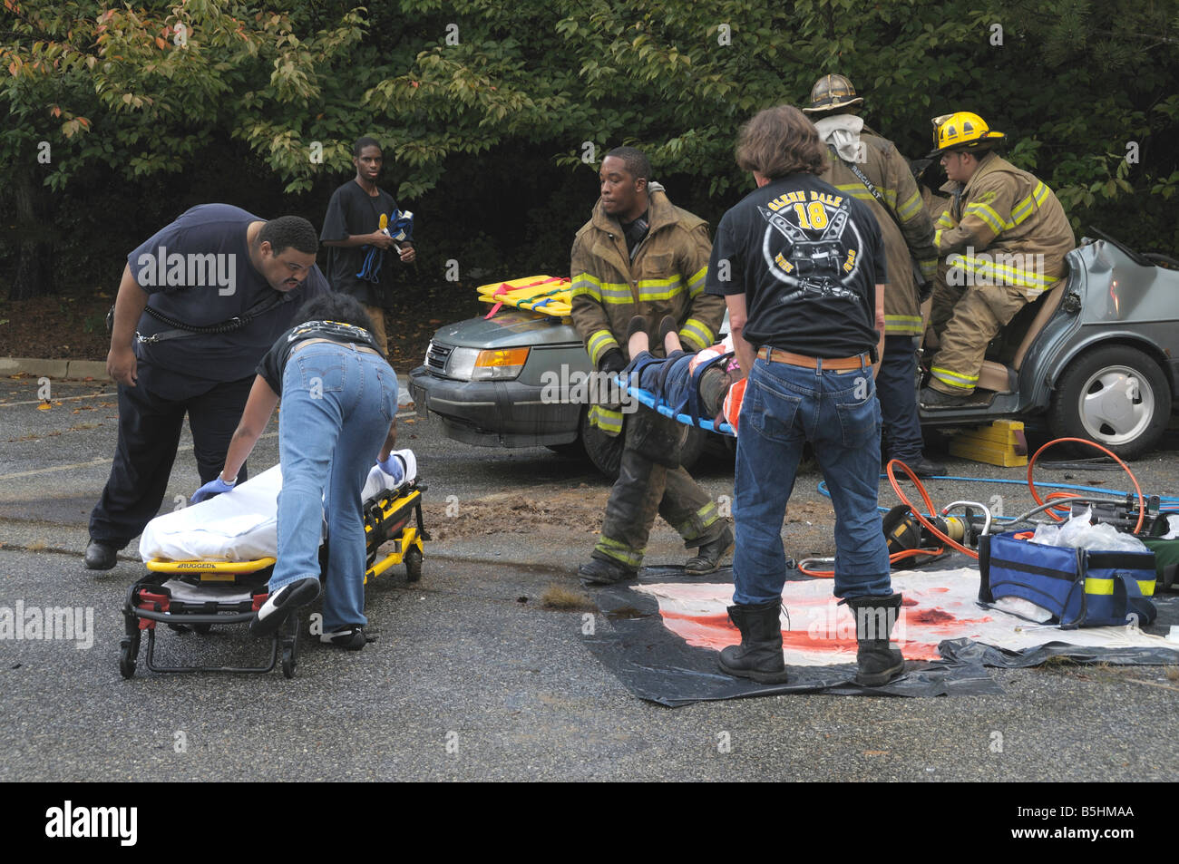 firefighters carry an injured man on a backboard to a stretcher after ...