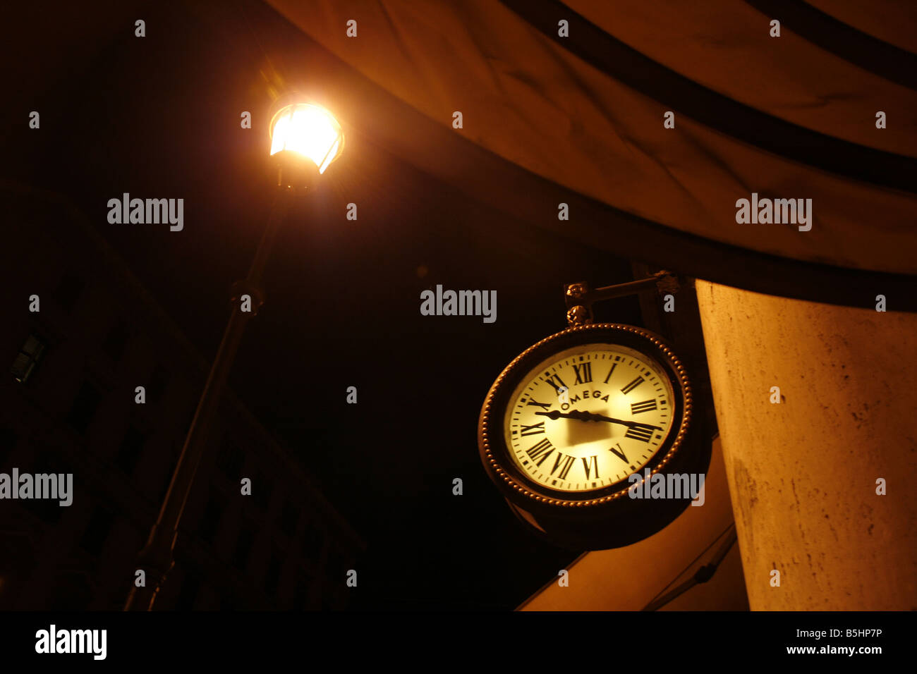 one old fashion clock in city street at night Stock Photo - Alamy