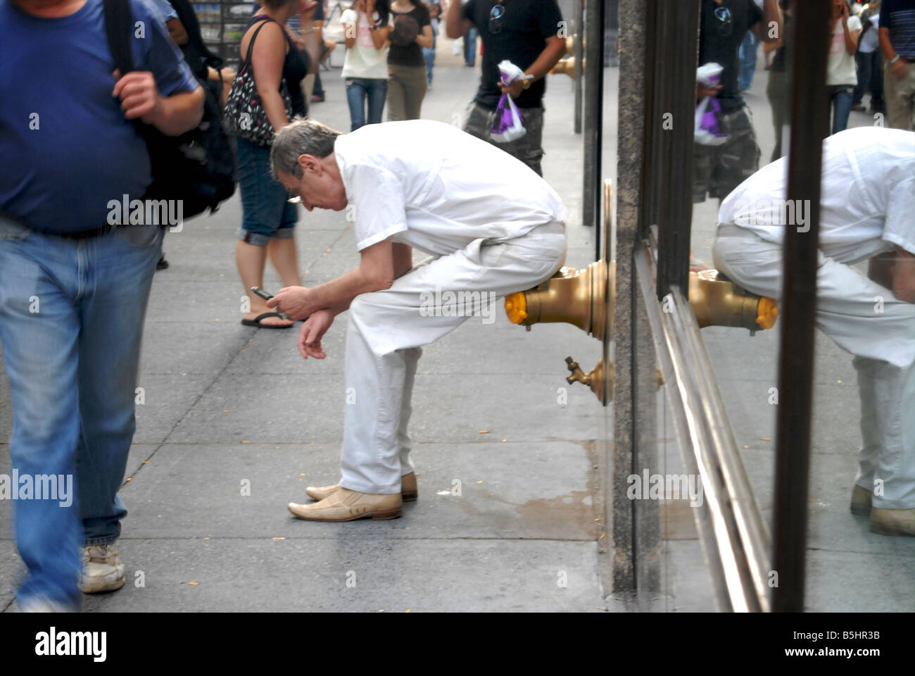 A man sitting on a fire hydrant near the Rockefeller Center, with ...