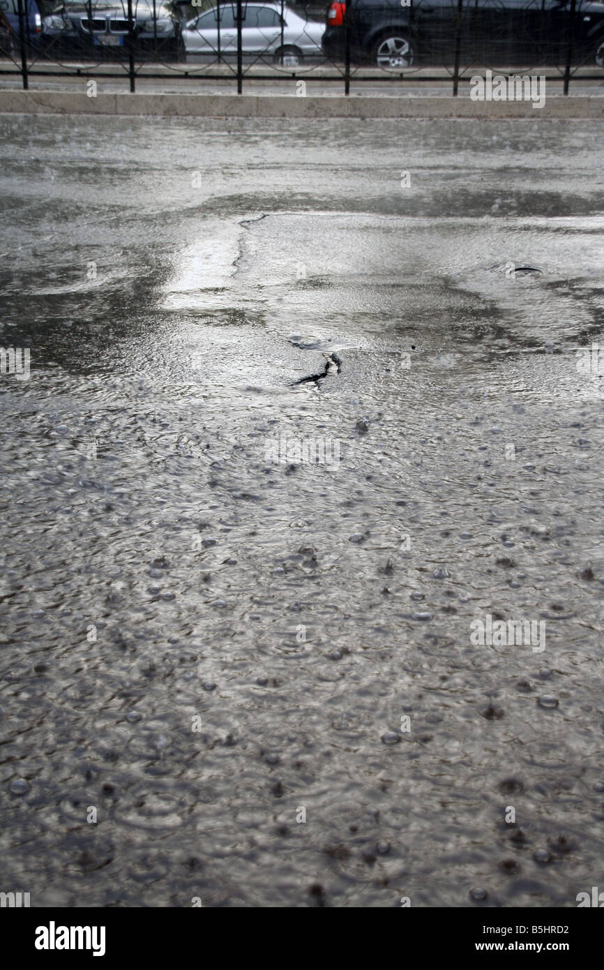 lots rain drops falling in water puddle in street Stock Photo - Alamy