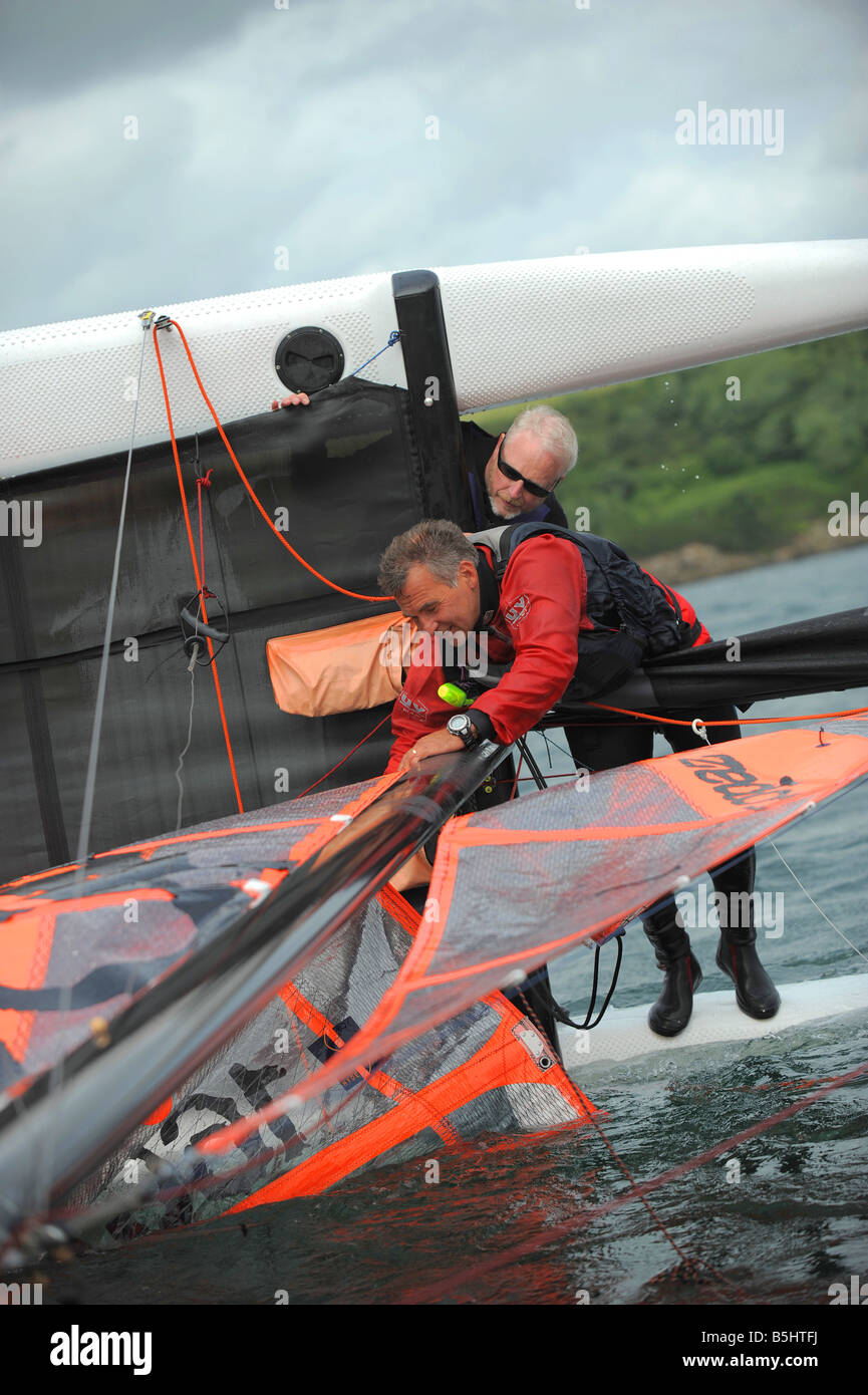 Two men trying to right a capsized catamaran on a Catamaran Conversion ...