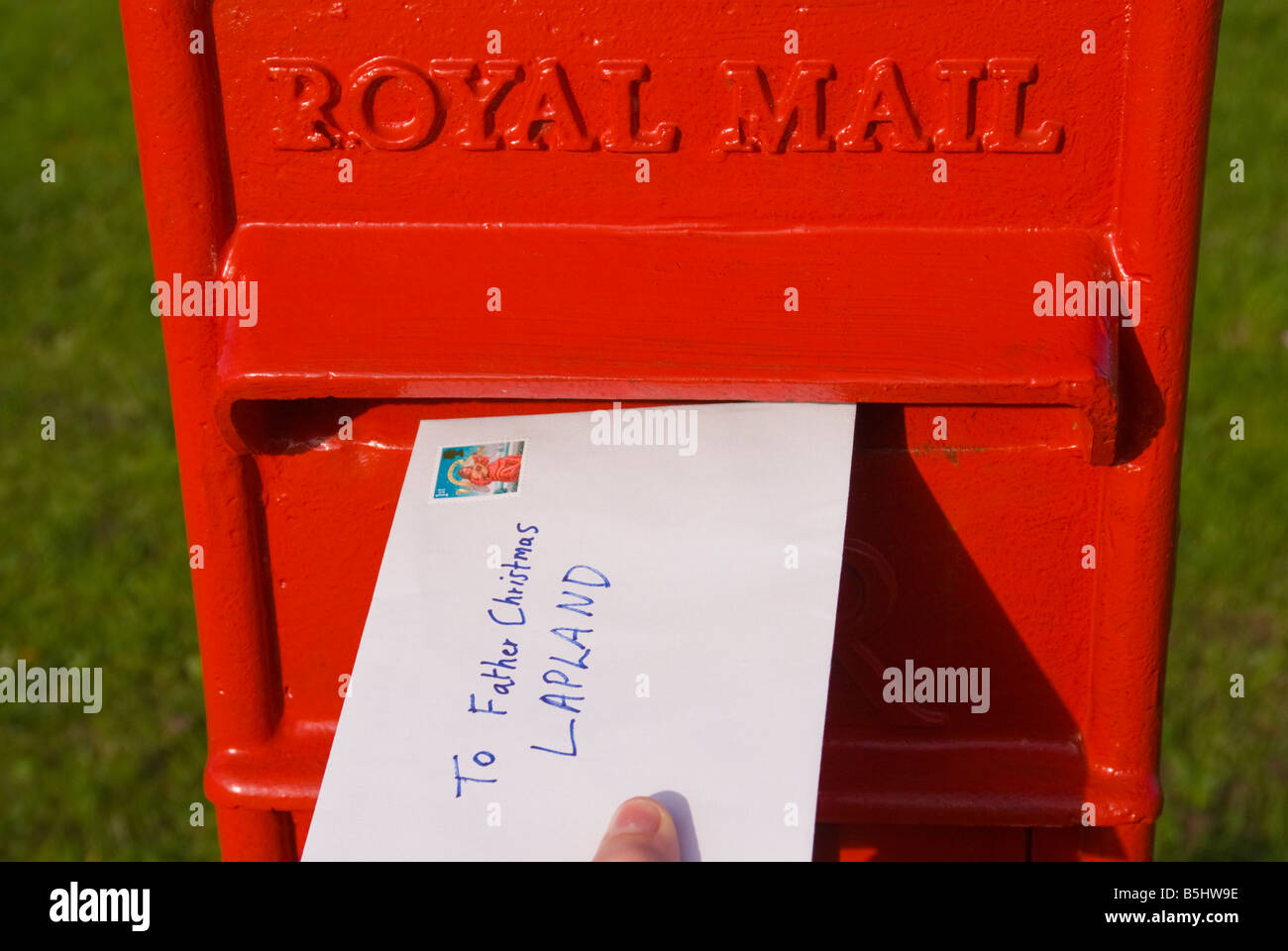 A letter being posted in Uk Royal Mail postbox addressed to Father ...