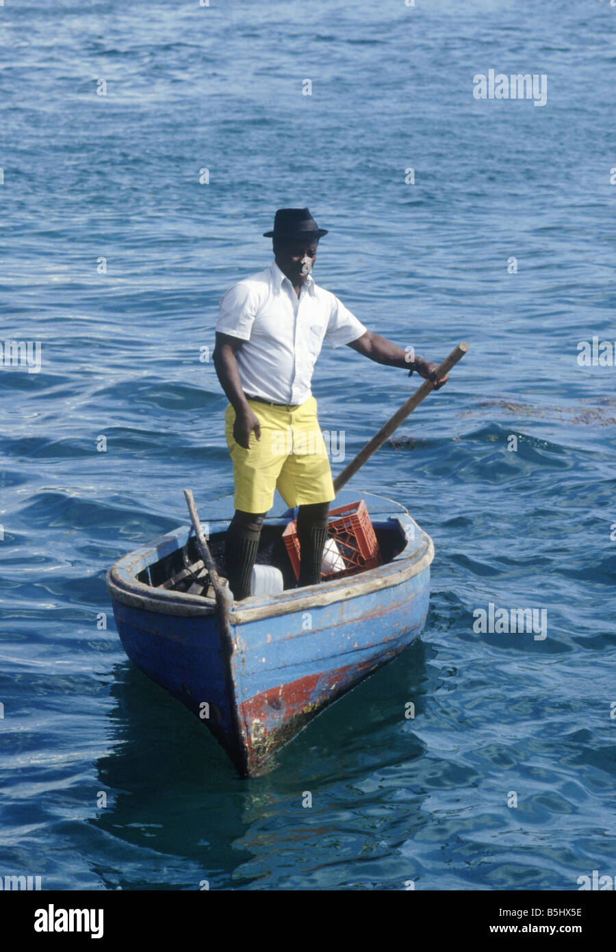 Man guides wooden boat to dock in Nassau Stock Photo - Alamy
