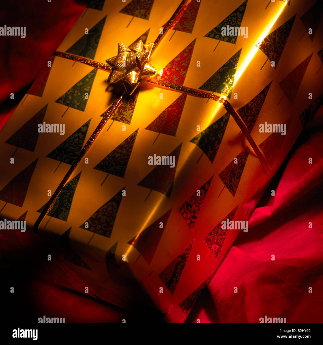 GOLD WRAPPED CHRISTMAS PRESENT ON RED VELVET Stock Photo - Alamy