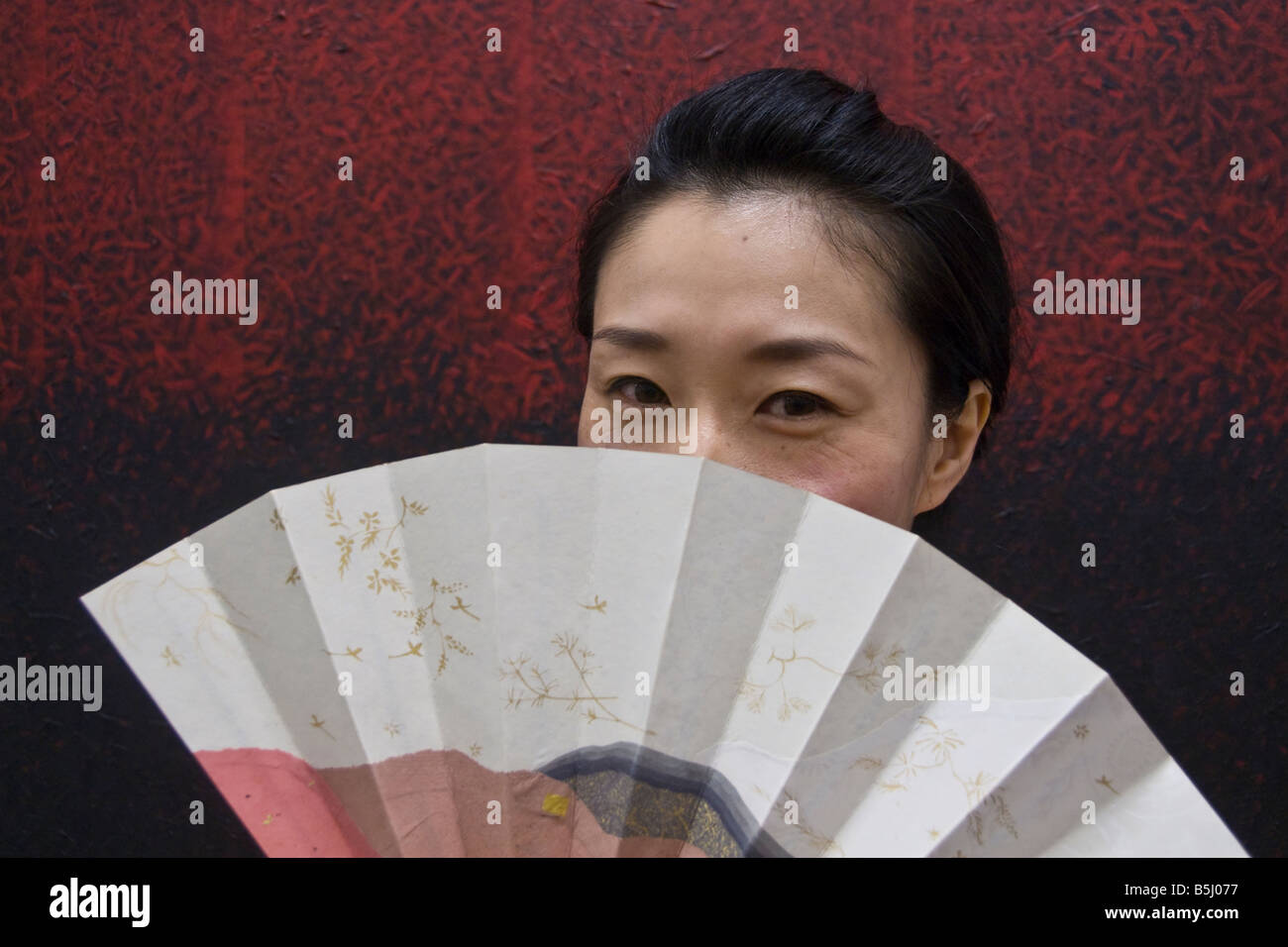 Japanese woman hiding her face behind a traditional fan Stock Photo - Alamy