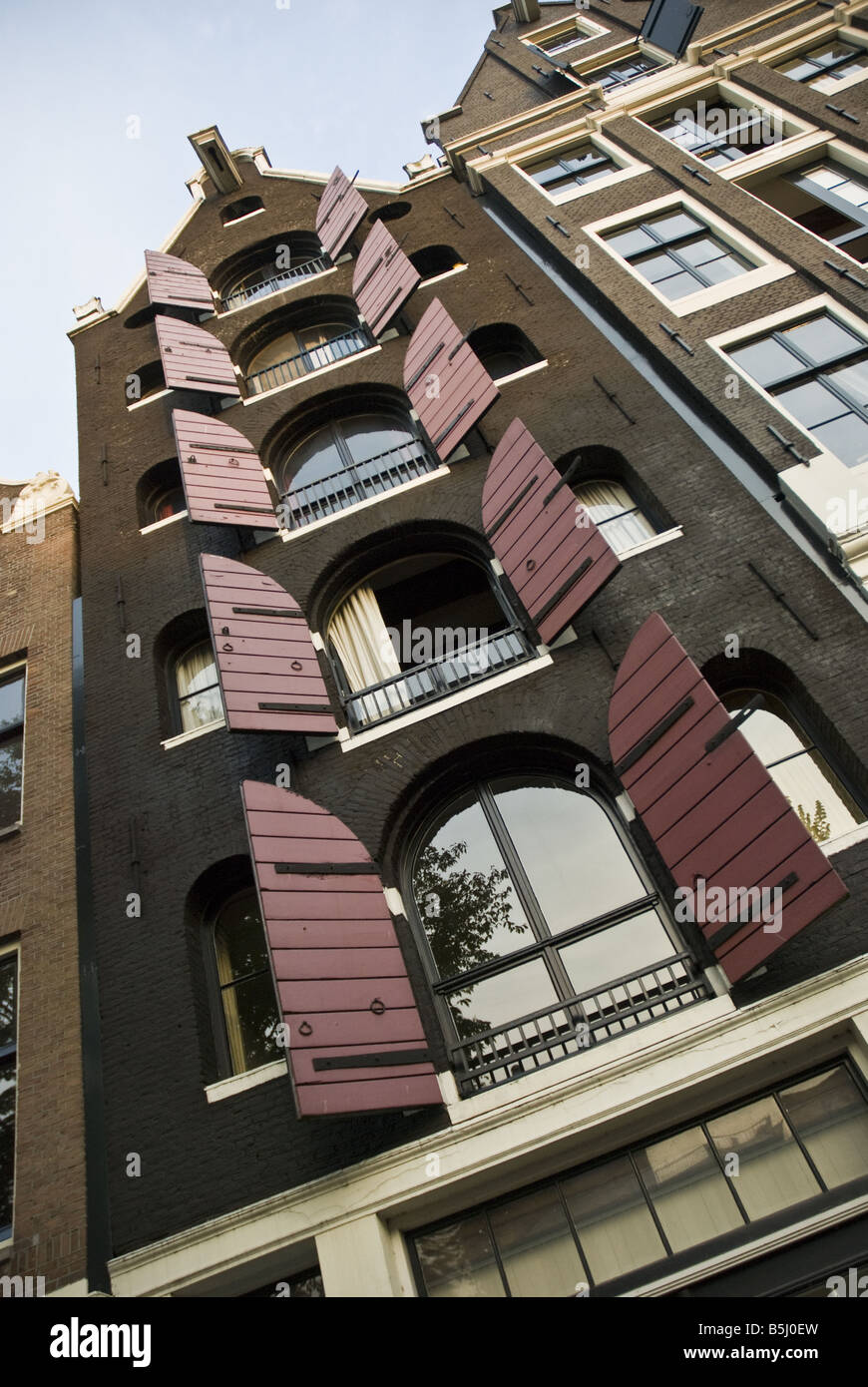 A traditional Amsterdam canal side terrace with open wooden shutters ...