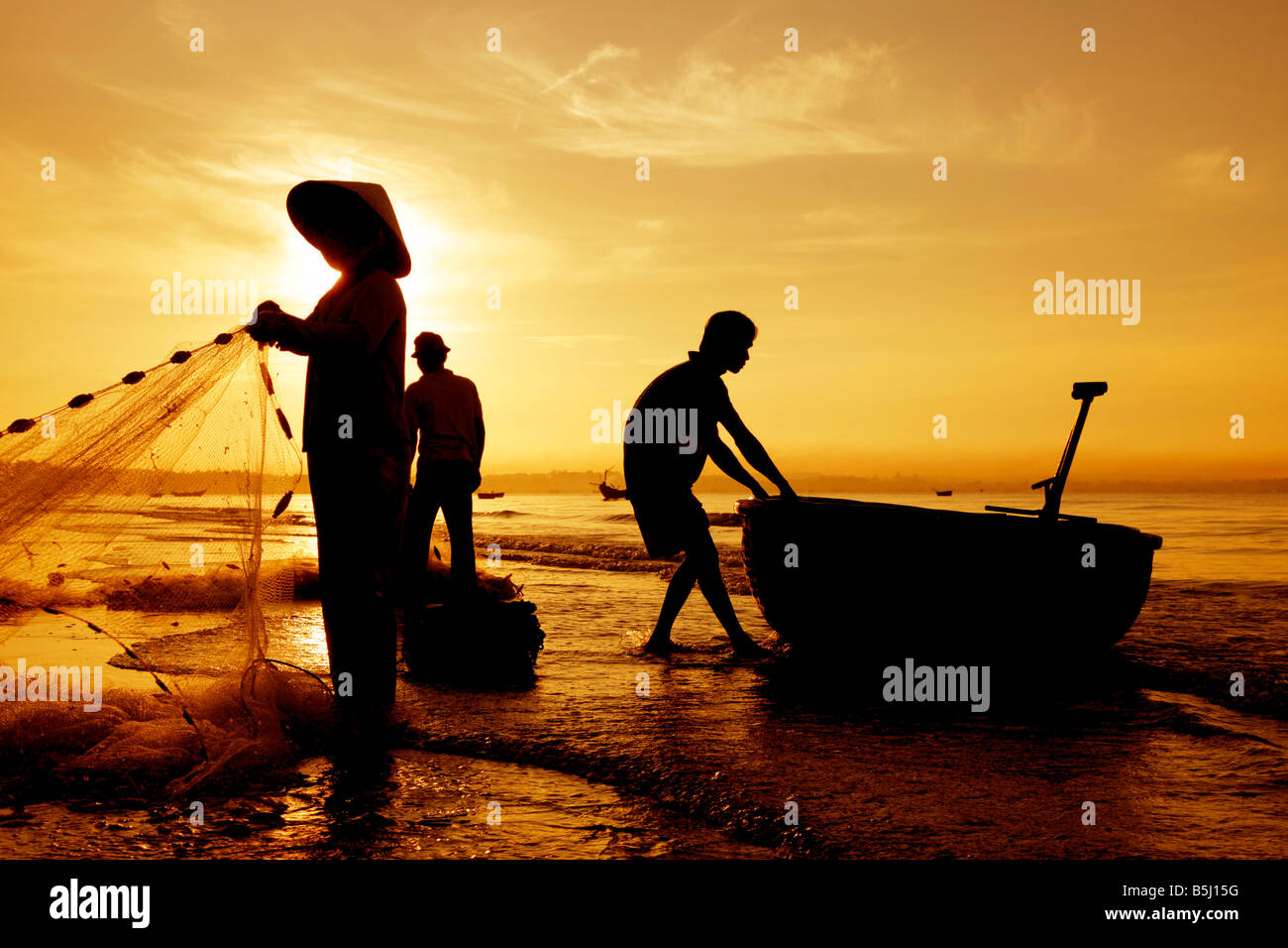 Fishermen on Mui Ne beach at sunrise with coracle and nets Stock Photo ...