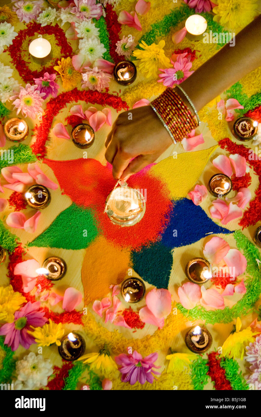 View of a hand lighting up some candles for the Indian Diwali light ...