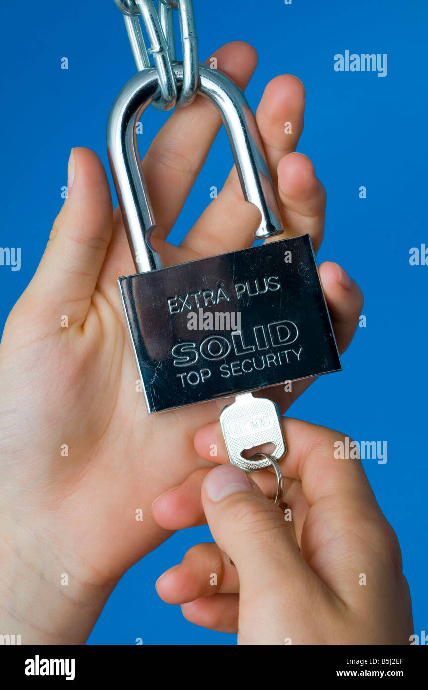 Hands securing a strong padlock with key Stock Photo - Alamy