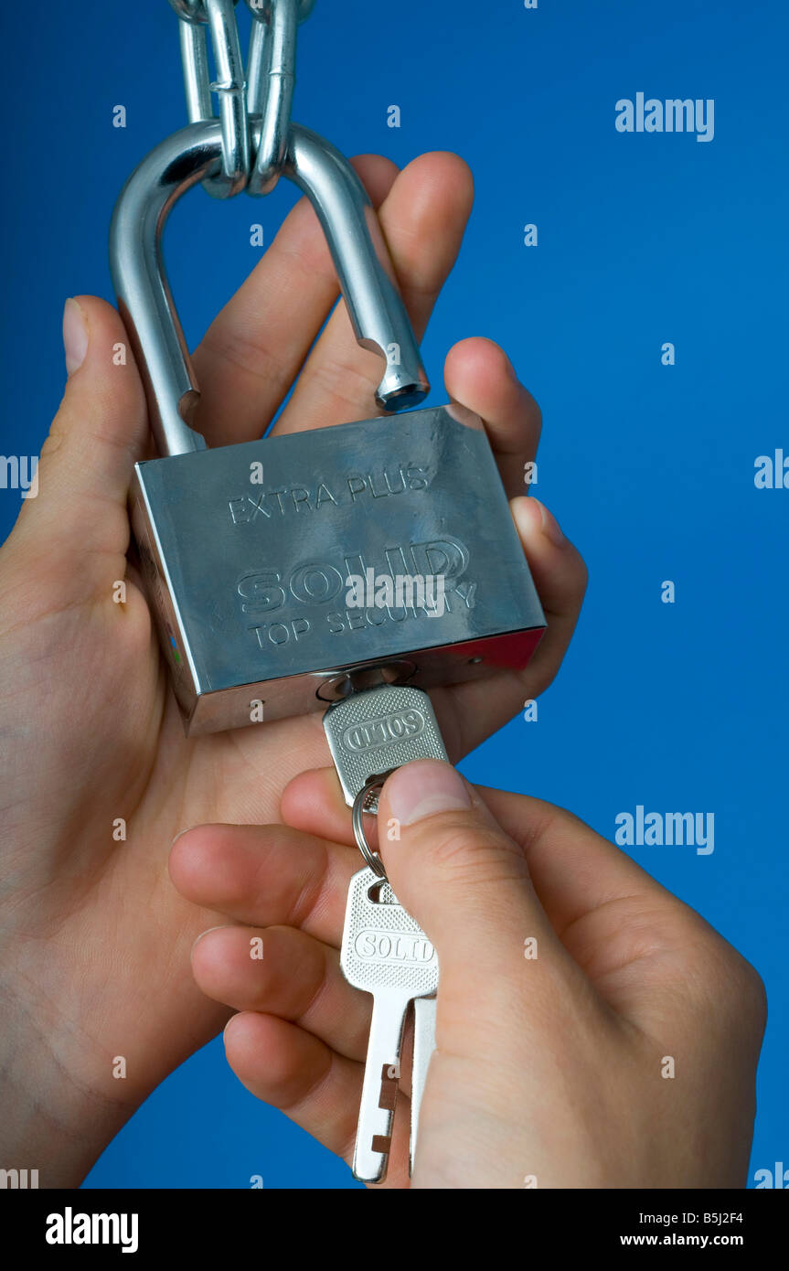 Hands securing a strong padlock with key Stock Photo - Alamy