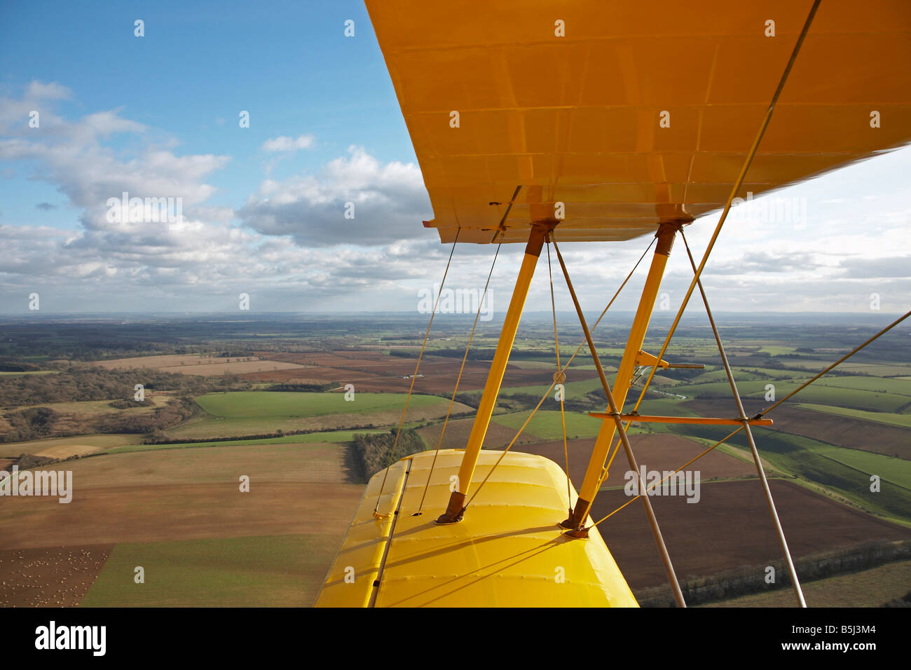 View across the wing from the cockpit of a vintage biplane above the ...