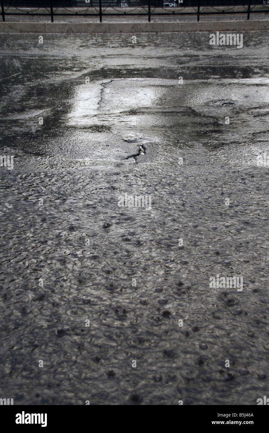lots rain drops falling in water puddle in street Stock Photo - Alamy