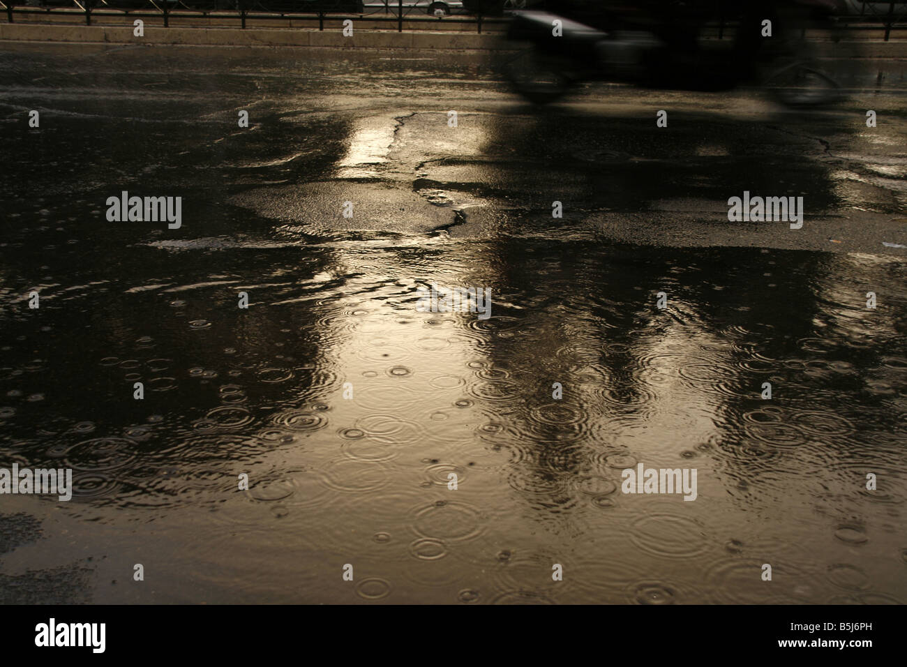 lots rain drops falling in water puddle in street Stock Photo - Alamy