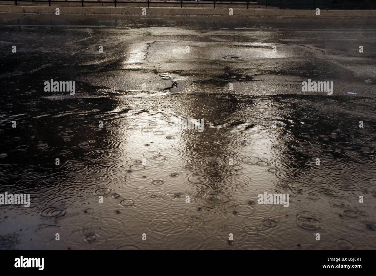 lots rain drops falling in water puddle in street Stock Photo - Alamy