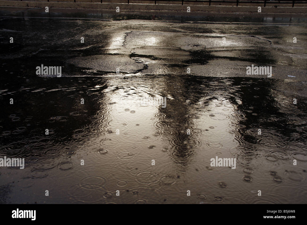 lots rain drops falling in water puddle in street Stock Photo - Alamy