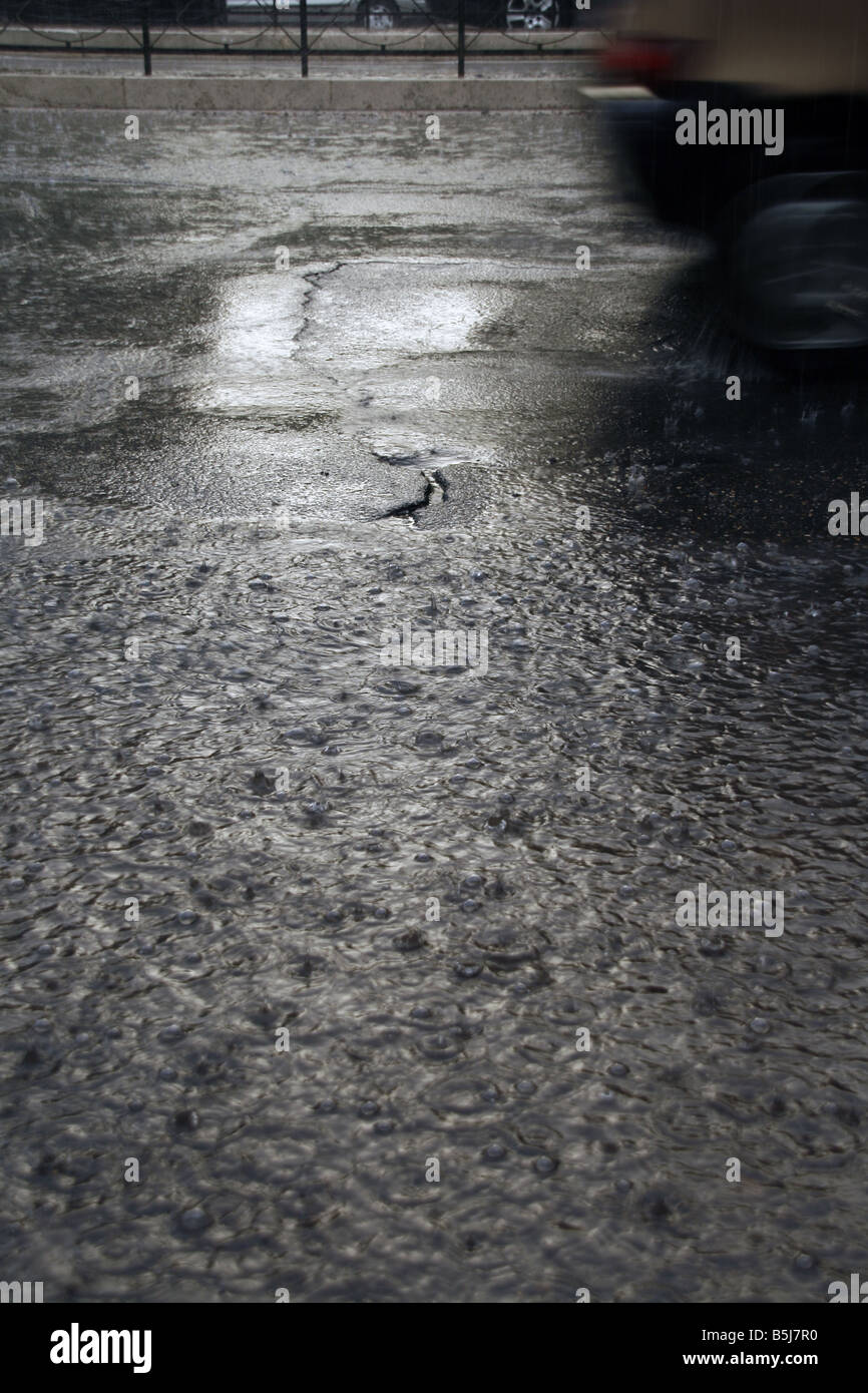 lots rain drops falling in water puddle in street Stock Photo - Alamy
