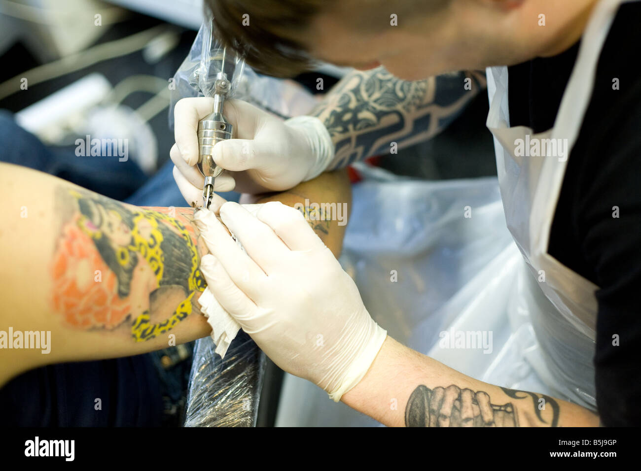 Man having his arm tattooed Stock Photo - Alamy