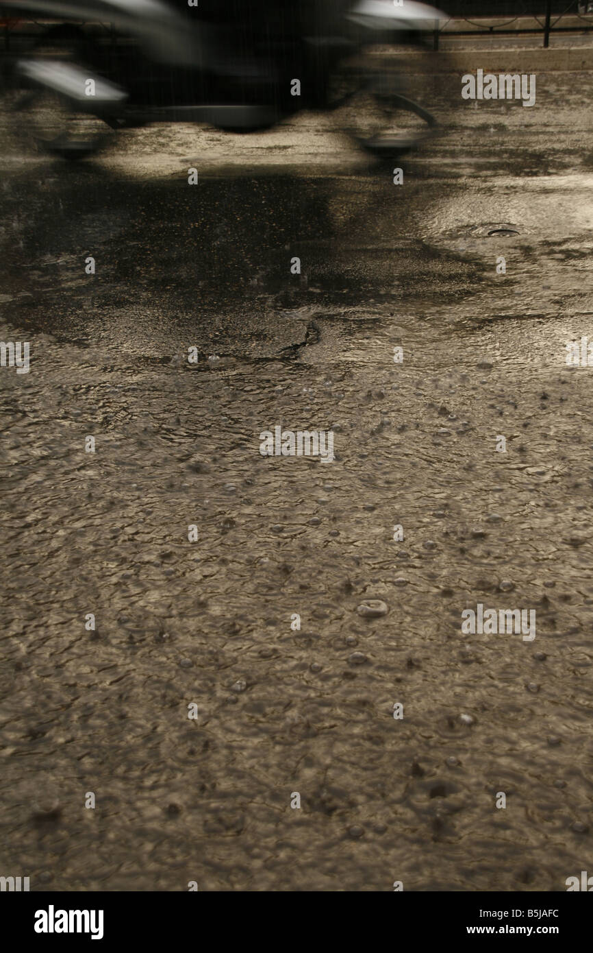 lots rain drops falling in water puddle in street Stock Photo - Alamy